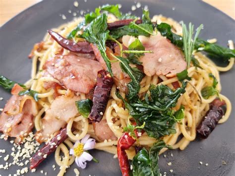 Close Up Stir Fried Spaghetti With Dried Chili And Crispy Bacon Stock