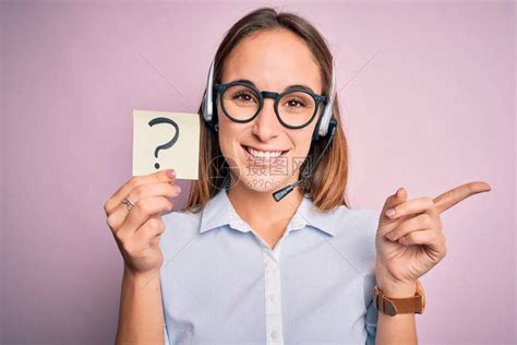 美丽的呼叫中心探员女使用耳头戴警徽拿着提示带问号十分快乐地用手和高清图片下载 正版图片504373834 摄图网