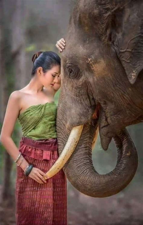 A Woman Is Hugging An Elephant With Her Trunk