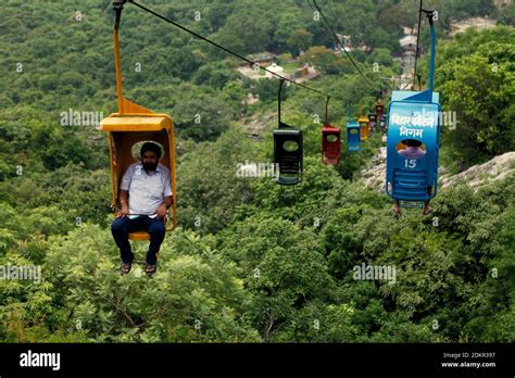 Visitors Making A Journey Using One Seated Wagons On A Ropeway System