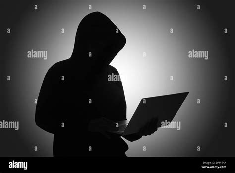 Mysterious Man Wearing Black Hoodie Using Laptop In The Dark Room