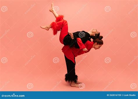 Happy Two Young Caucasian Girls Have Fun Lifting Each Other Up On Their