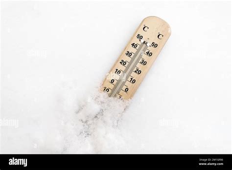 Wooden Thermometer On Snow Shows Low Temperature Below Zero In Celsius