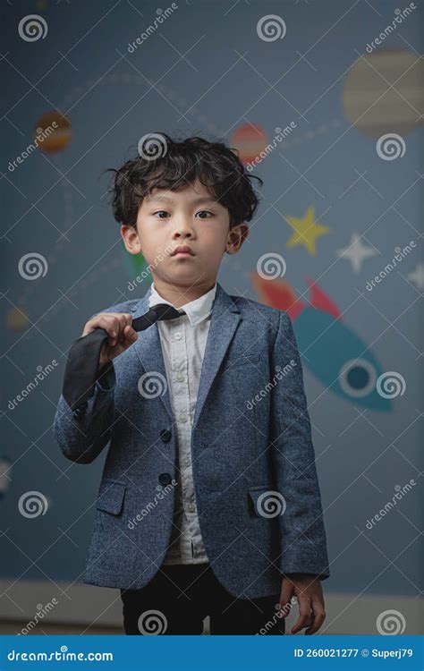 A Little Boy In A Suit Looks Seriously At The Camera Stock Image