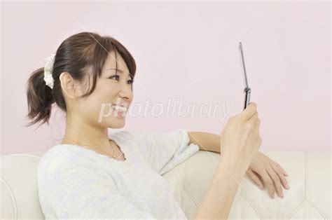 笑顔で携帯電話を見る女性 写真素材 1352735 フォトライブラリー Photolibrary