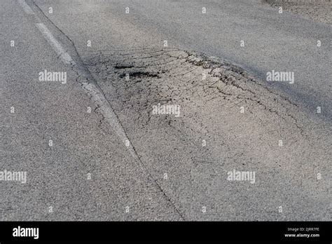 Deformed Asphalt Surface With Potholes Caused By Heavy Overloaded