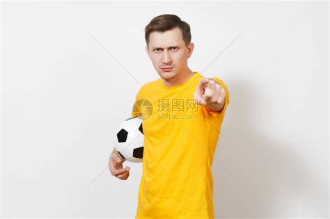 年轻的愤怒的欧洲男子球迷或身穿黄色制服的球员拿着足球点食指相机欢呼最喜欢的足球队高清图片下载 正版图片505168361 摄图网