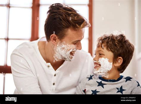 Having Fun With His First Shaving Lesson A Man Teaching His Young Son How To Shave At Home