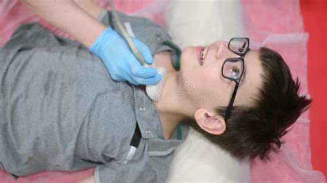 Doctor Making Ultrasound Of Thyroid Gland For Boy Using Scanner Machine