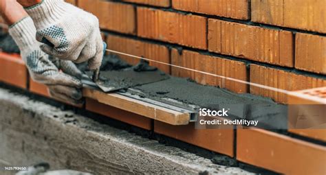 메이슨 흙은 벽돌에 시멘트 모르타르를 얼룩지게합니다 집이나 돌 울타리를 지을 때 벽돌 쌓기 개발에 대한 스톡 사진 및 기타 이미지 Istock