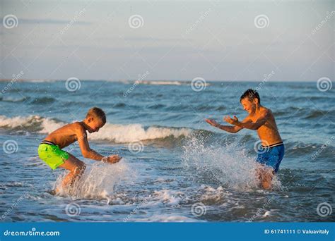 Twee Jongens Die Bij Het Strand Met Water Spelen Stock Afbeelding