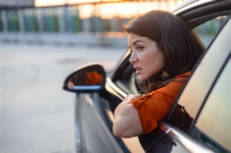 Premium Photo Young Woman Peeking Out Of Car Window Woman With In The