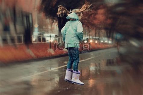 秋雨中跳水坑的女孩高清摄影大图 千库网