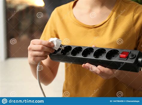 Woman Inserting Power Plug Into Extension Cord Indoors Space For Text Electrician S Stock