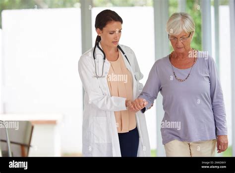 Post Op Recovery Assistance A Senior Woman Walking Carefully With Help
