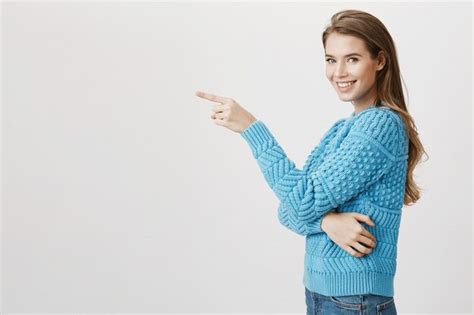 Привлекательная улыбка счастливая женщина указывая пальцем вправо