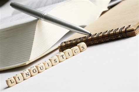만년필 옆에 있는 단어 언어학 오픈 북 및 메모장 인문학 연구 개념 학술 과목 문학 창의적인 글쓰기 및 언어학 흰색 배경입니다