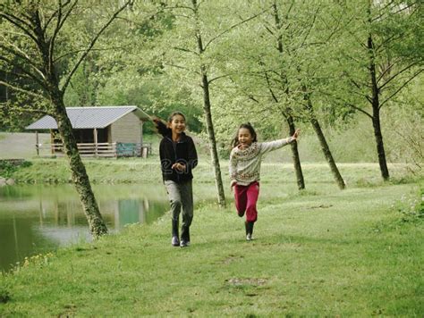 Two Mixed Race Girls Running Around In The Wilderness Stock Image