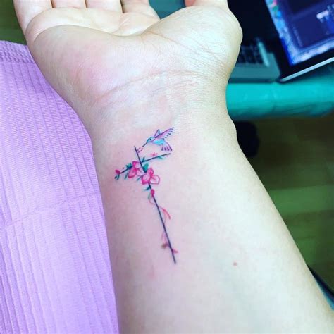 Tatoo de colibrí flores y cruz Cross tattoos for women Wrist tattoos for women Tasteful