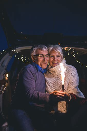 수석 부부는 오픈 자동차 트렁크에 앉아서 자신의 손에 스파크 스틱을 잡아 겨울에 대한 스톡 사진 및 기타 이미지 겨울 관광객 노인 Istock