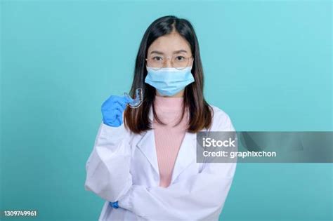 치과 의사 여자 블루 스크린 배경에 치열 교정 보유자를 들고 치과 치료와 건강한 치아 20 24세에 대한 스톡 사진 및 기타 이미지 20 24세 건강관리와 의술