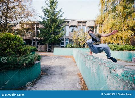 Athletic Parkour Guy Doing Backflip And Tricks While Jumping Off And
