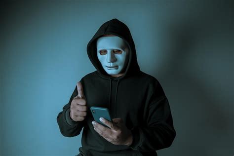Premium Photo An Anonymous Masked Hacker Is Using A Smartphone To