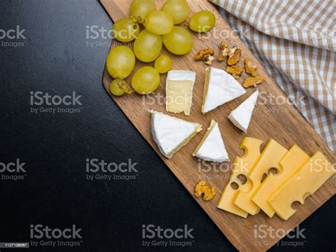 치즈 견과 및 포도 나무 절단 보드에 쪼 갠 다 카망베르 치즈와 치즈에 담입니다 와인 및 낭만주의 대 한 음식입니다 상위 뷰