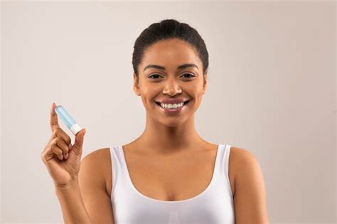 Premium Photo Woman Applying Hygienic Lip Balm On Light Background