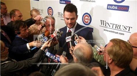 A Man In A Suit And Tie Surrounded By Reporters