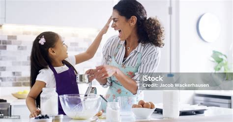 장난기 많고 엄마와 소녀는 부엌에서 베이킹과 디저트 케이크를 위한 재료로 배우고 유대감을 형성합니다 미소 행복한 엄마 요리 딸을 가르치며 지원 쿠키 또는 레시피를 집에서