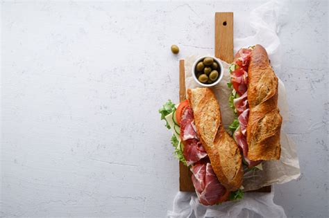 두 신선한 바게트 샌드위치 Bahn Mi의 상위 뷰 스타일 햄 치즈 토마토와 신선한 양상추를 콘크리트 바탕에 어두운 나무 절단