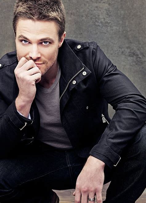 A Man Sitting Down With His Hand On His Chin And Looking At The Camera