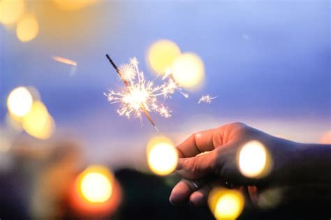 Premium Photo Hand Holding Illuminated Firework Display At Night