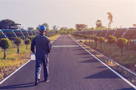 Premium Photo Rear View Of Electrician Walking On Road Amidst Solar Panels