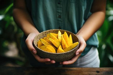 Premium Ai Image Two Hands Holding A Bowl Of Mangoes