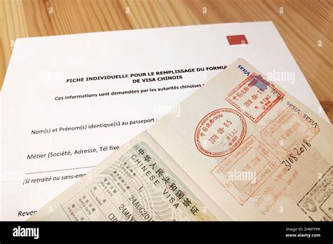 Opened French Passport On The Top Of An Application Form For A Chinese