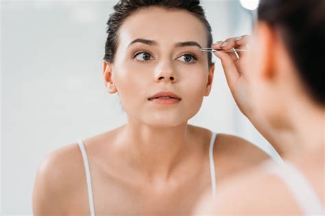 족집게로 눈 썹을 교정 하 고 욕실에서 거울을 보고 여자의 선택적 초점 가정 생활에 대한 스톡 사진 및 기타 이미지 가정