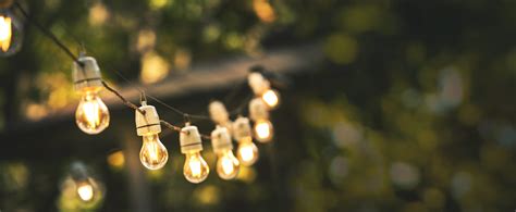 Outdoor Party String Lights Hanging In Backyard On Green Bokeh