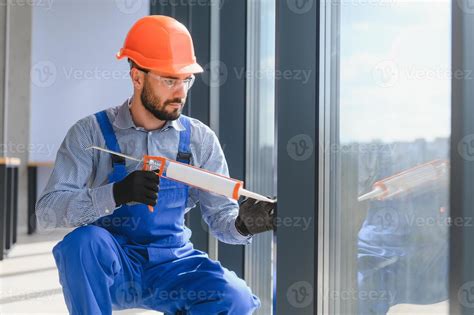 Workers With Tube Of Sealant And Suction Lifters Installing Plastic