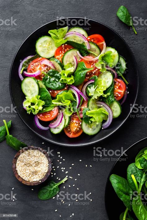 신선한 토마토 오이 양파 시금치 상 추와 접시에 참 깨의 건강 한 야채 샐러드 다이어트 메뉴입니다 최고의 볼 수 있습니다 건강한