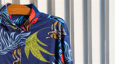 나무 걸이에 열대 꽃 무늬가있는 블루 하와이 셔츠는 흰색 판자 벽 배경에 매달려 있습니다 0명에 대한 스톡 사진 및 기타 이미지 0명 가정 생활 꽃 식물 Istock