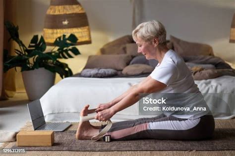 요가를 연습하는 수석 백인 여성 앉아있는 전방 굽힘 운동 파스치모타나사나 포즈 건강한 생활방식에 대한 스톡 사진 및 기타 이미지 건강한 생활방식 노인 노트북 Istock