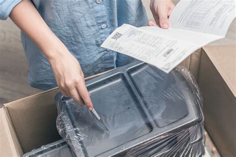 송장과 문구 칼을 들고 홈 오프닝 판지 상자에 바닥에 앉아 여성 구매자는 인터넷 상점에서 소포 패키지를 받았습니다 배달 서비스