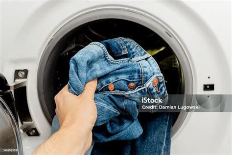 세탁기의 드럼에 청바지를 넣는 사람 정면도 세탁기에서 더러운 청바지 세탁 가사 집안일에 대한 스톡 사진 및 기타 이미지 가사