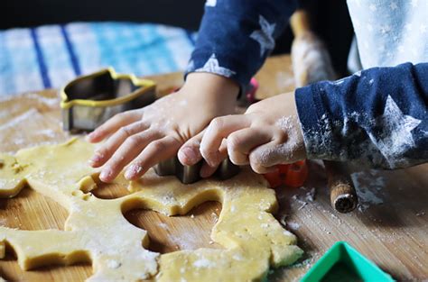 비스킷을 만드는 어린 아이 사용 후 생 비스킷을 들고 있는 아이 비스킷 커터 부엌에서 가족을 위해 크리스마스 에스테르 쿠키를 만드는 소년 굽기 전에 비스킷을 손으로 뚫습니다