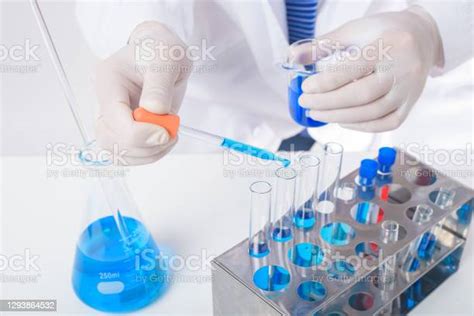 과학자의 클로즈업은 실험실 고립 된 흰색 배경에서 일부 파란색 액체 화학 물질을 테스트하고 연구하고 있습니다 Stem 주제에
