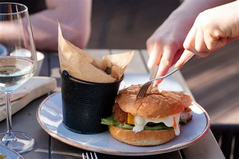 맥주와 와인 잔을 토스트하고 회복란에서 햄버거를 먹는 친구들의 그룹 햄버거와 음료를 곁들인 펍의 성인 2명에 대한 스톡 사진 및 기타 이미지 Istock