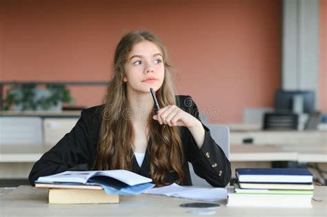 A Cute Schoolgirl Is Sitting At A Desk At School The Concept Of