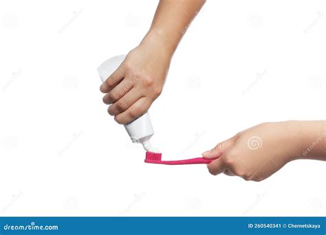 Woman Applying Toothpaste On Brush Against White Background Closeup